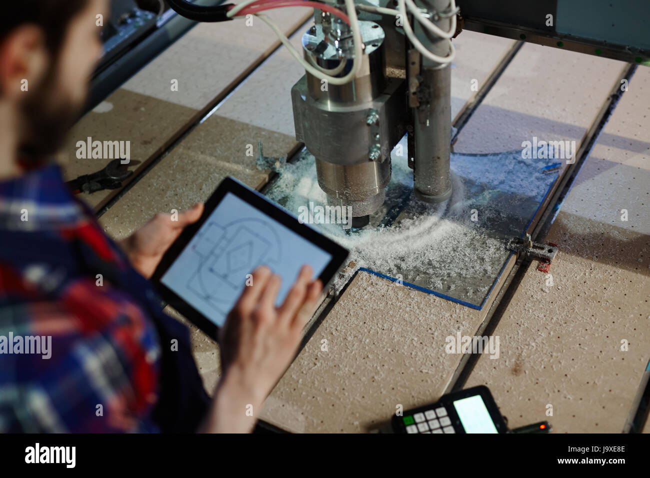 Lathe-machine engineer with touchpad learning sketch Stock Photo - Alamy