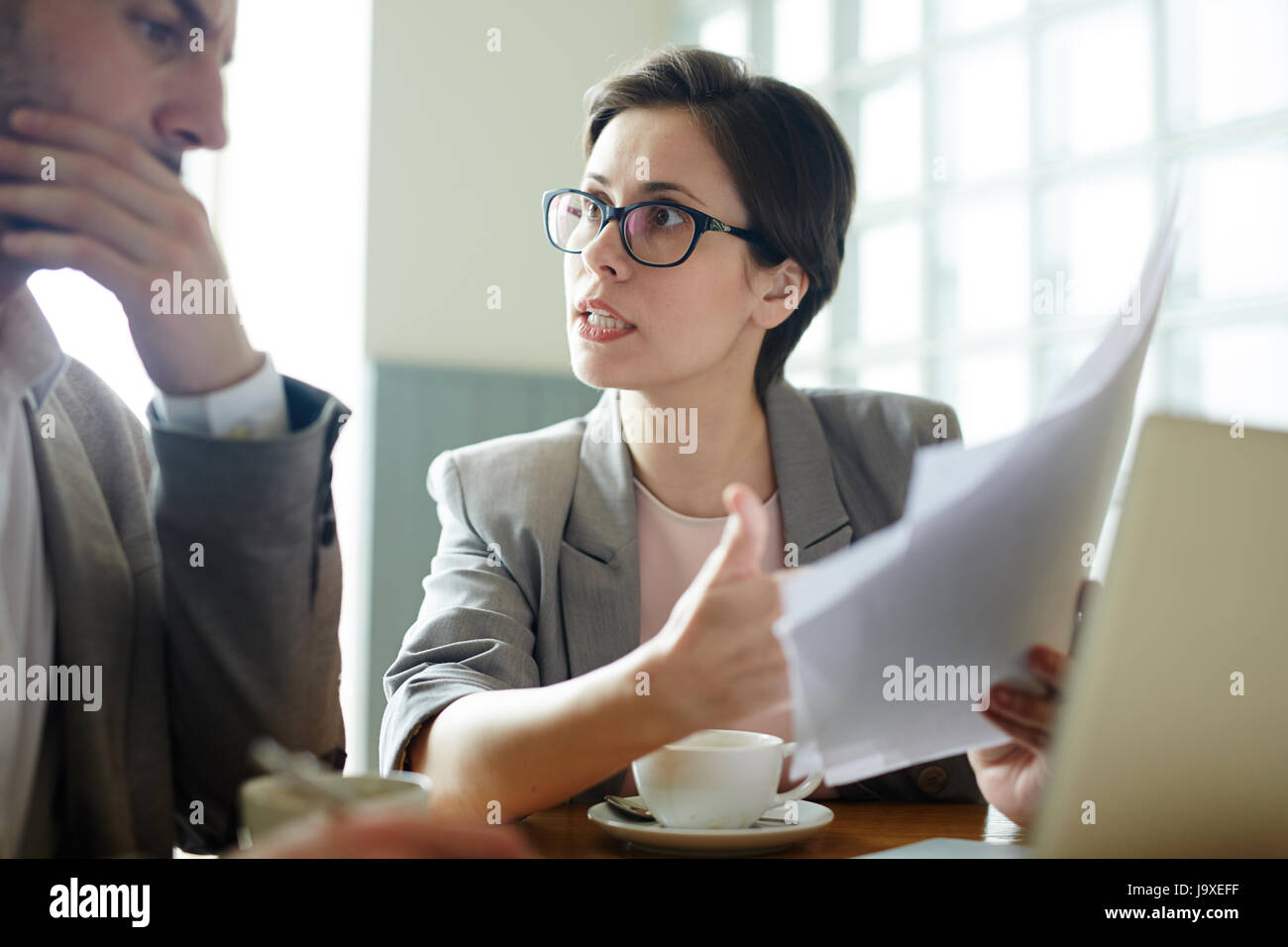 Two co-workers consulting while reading business contract Stock Photo ...