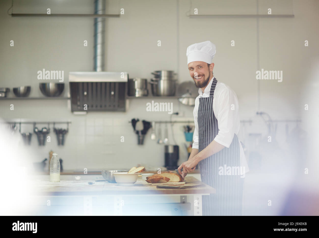 Owner of baker-shop slicing fresh bread in the kitchen Stock Photo - Alamy