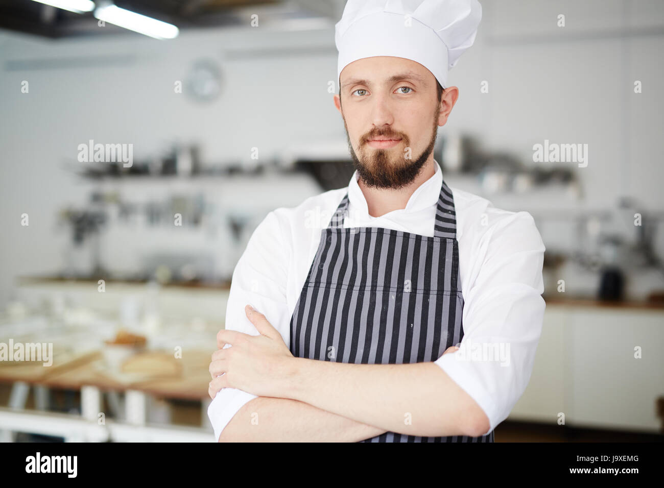 Bearded baker in uniform looking at camera Stock Photo - Alamy