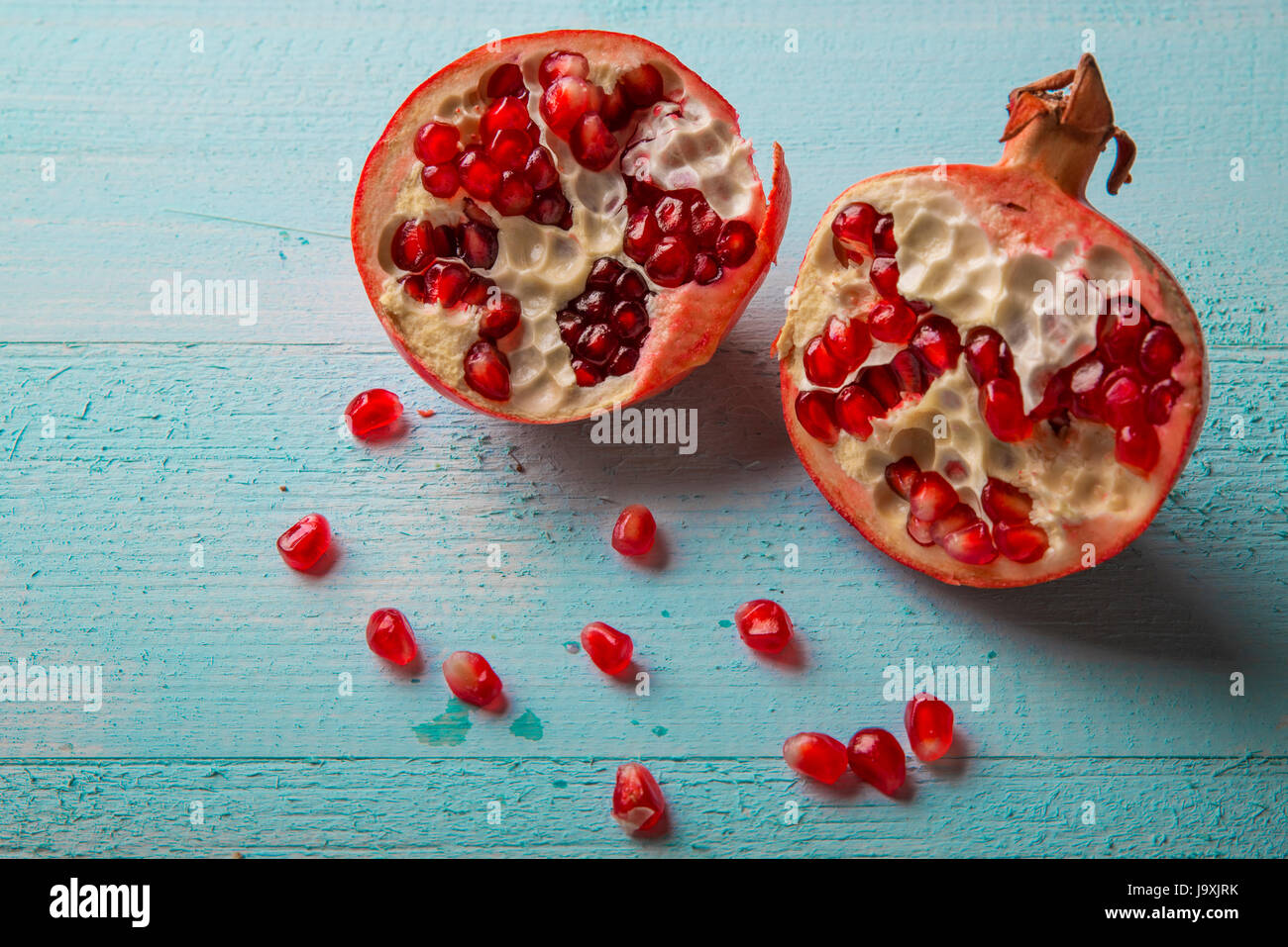 Open pomegranate on the old blue board Stock Photo - Alamy