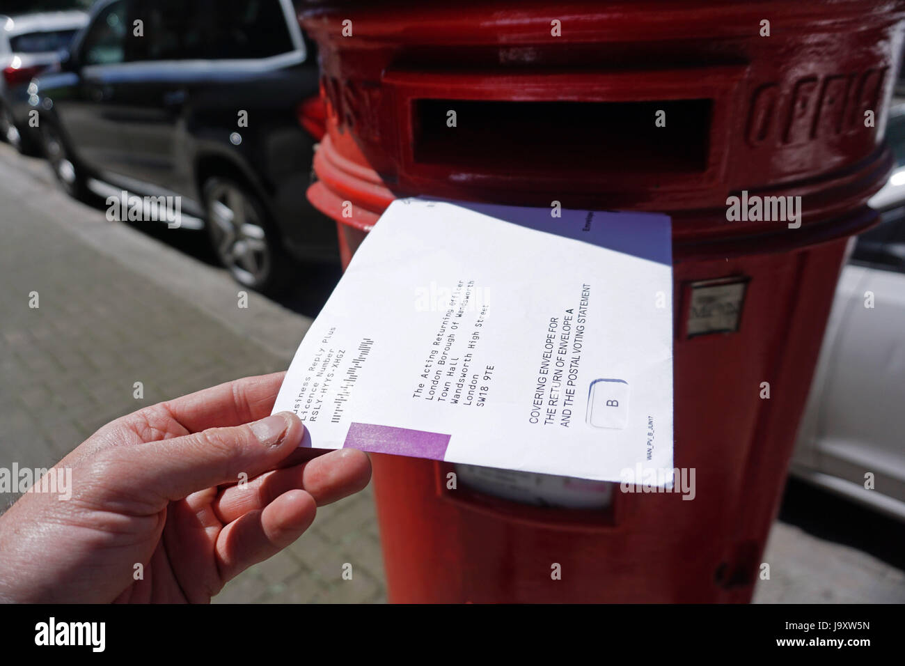 UK, London : A postal voting envelope is posted into a royal mail ...