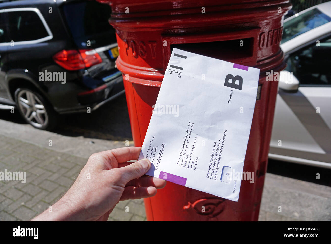 UK, London : A postal voting envelope is posted into a royal mail ...