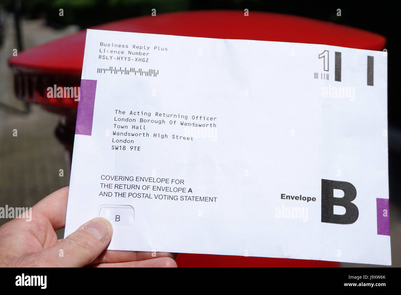 UK, London : A postal voting envelope is posted into a royal mail ...