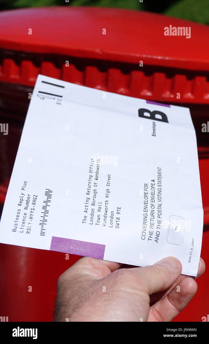 UK, London : A postal voting envelope is posted into a royal mail ...