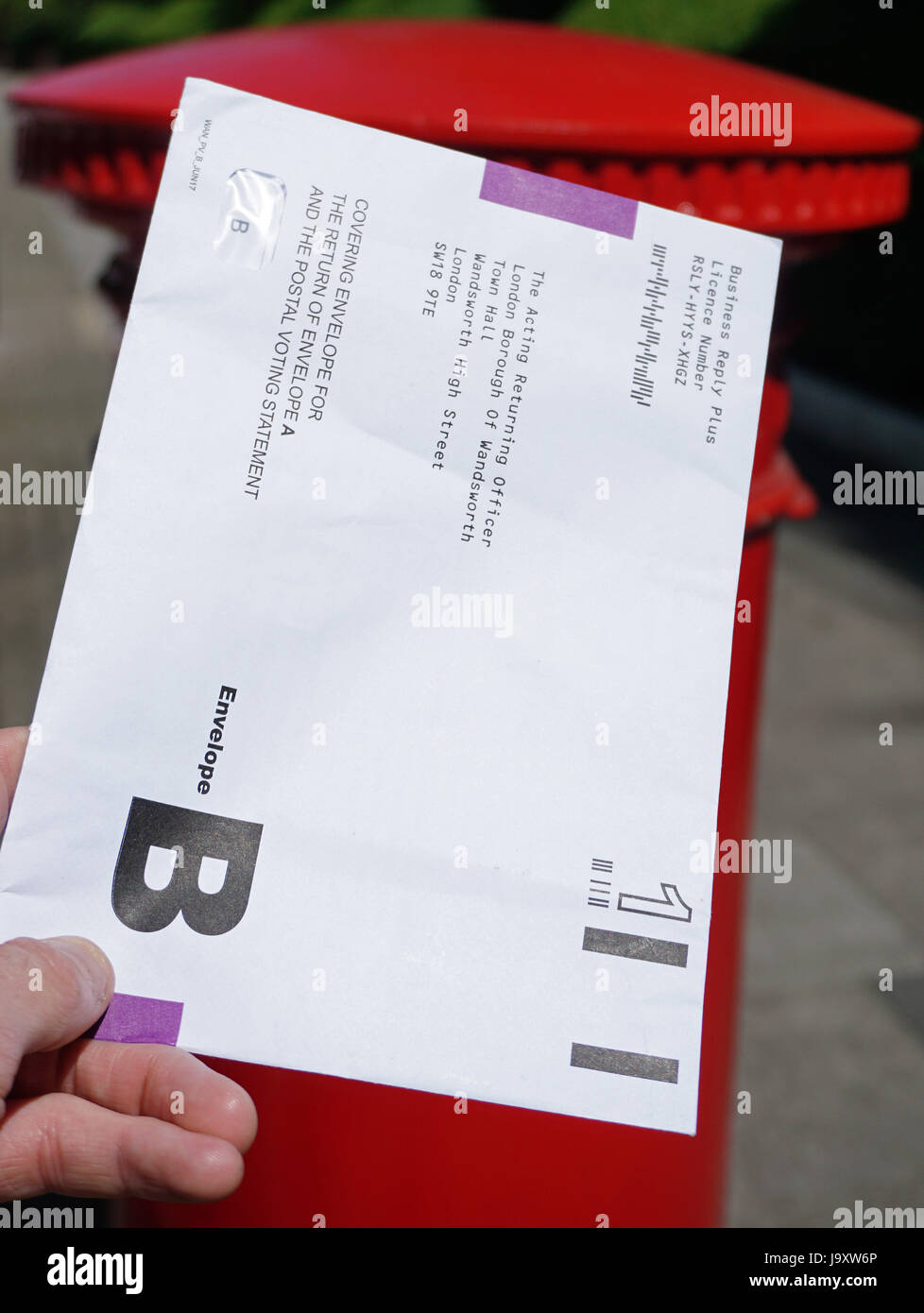 UK, London : A postal voting envelope is posted into a royal mail ...