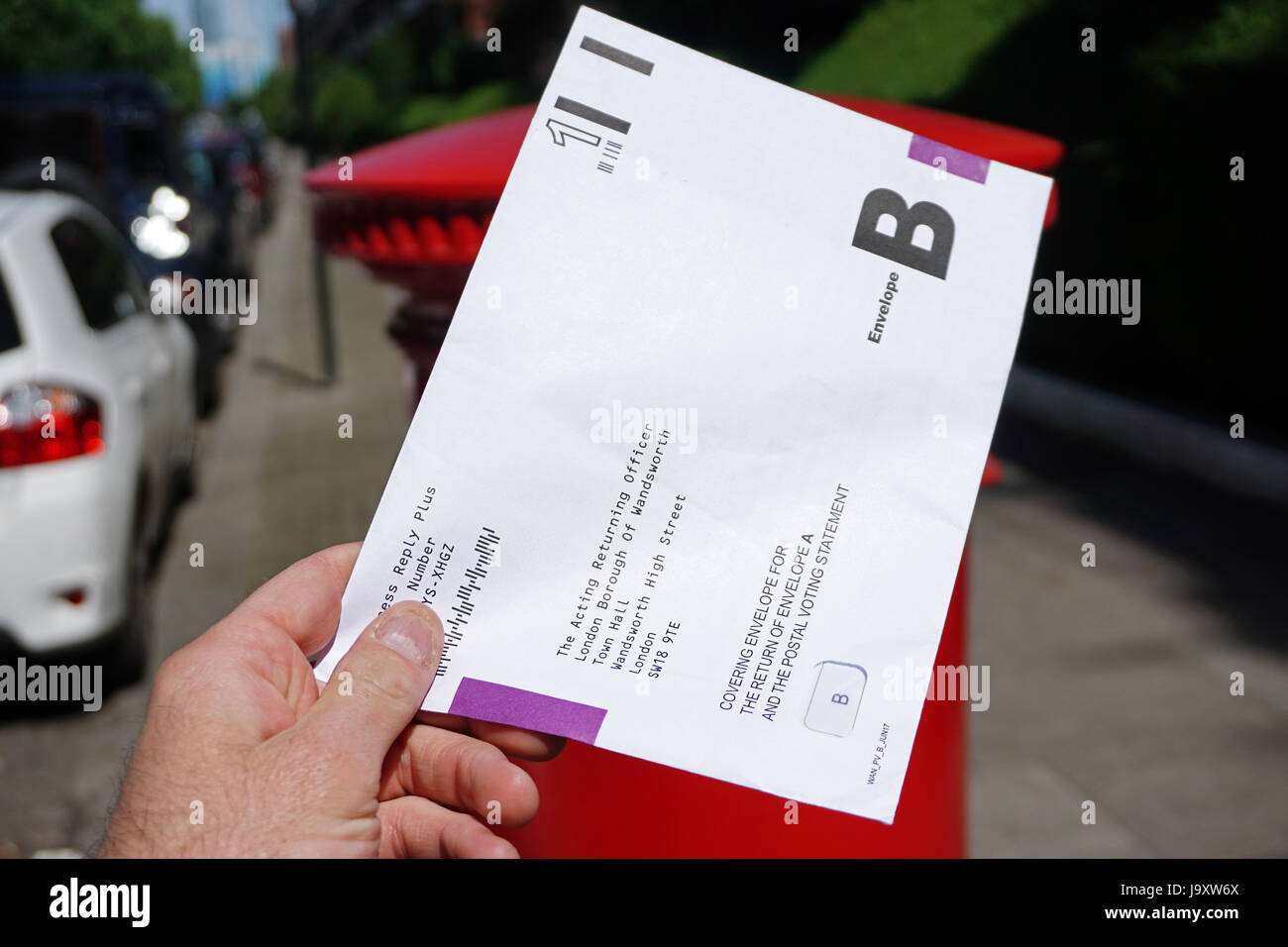 UK, London : A postal voting envelope is posted into a royal mail ...