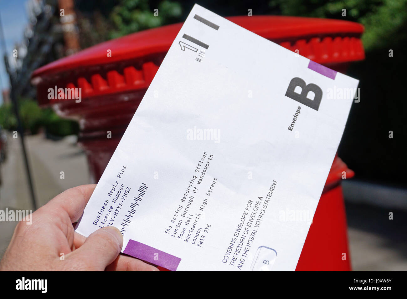 UK, London : A postal voting envelope is posted into a royal mail ...