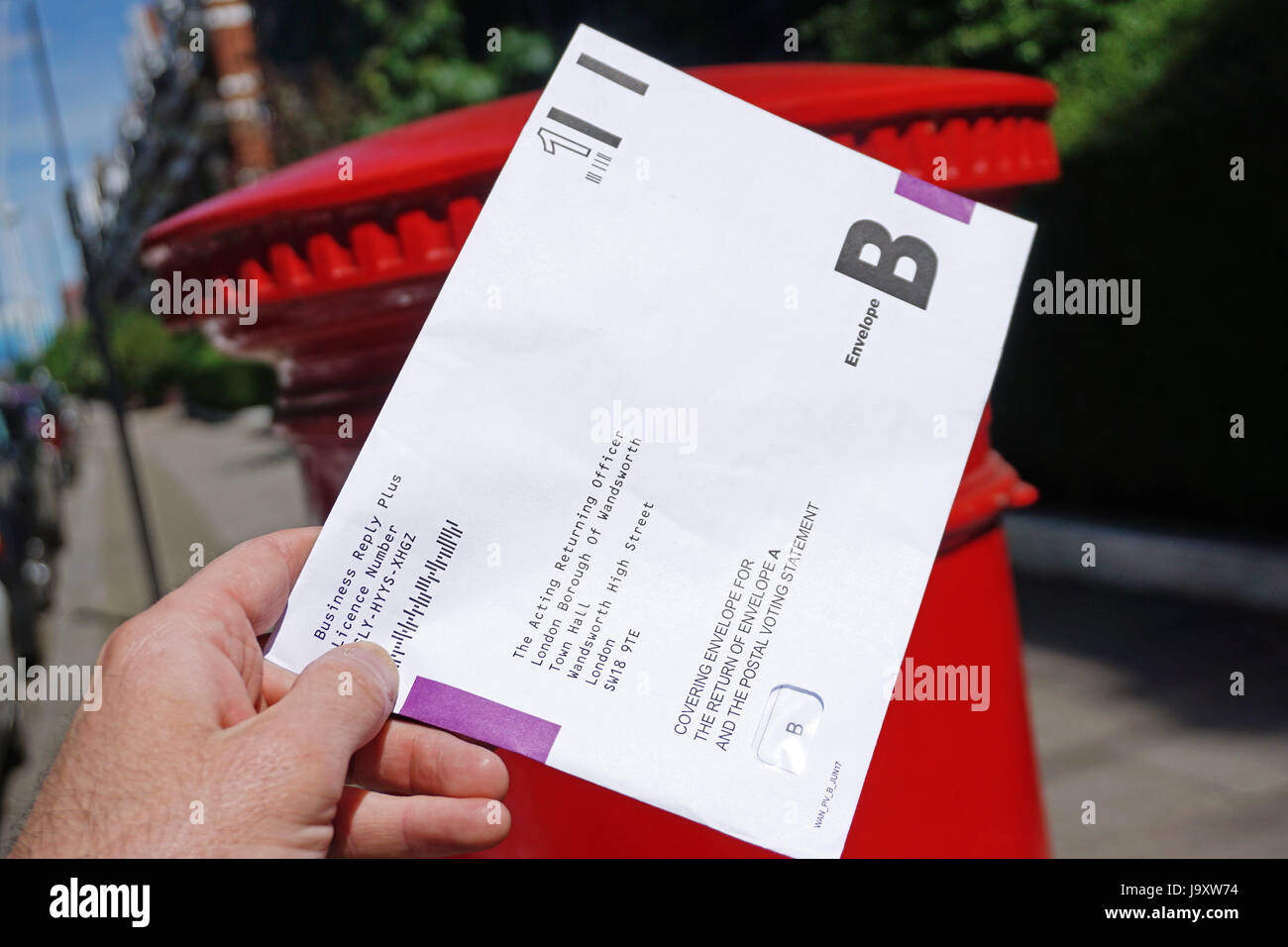 UK, London : A postal voting envelope is posted into a royal mail ...