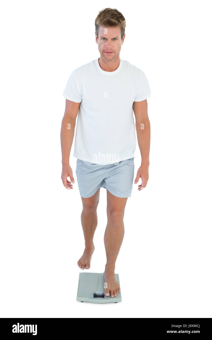 Man getting on his weighing scale on white background Stock Photo - Alamy