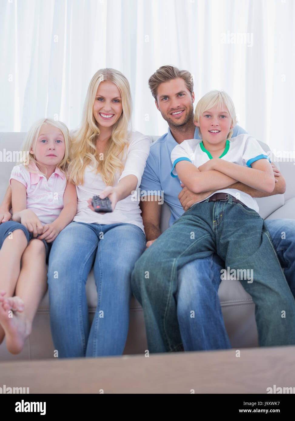 Parents and children watching TV in the living room Stock Photo - Alamy