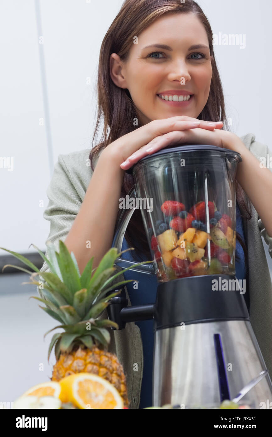 Attractive woman leaning on her blender in the kitchen Stock Photo - Alamy