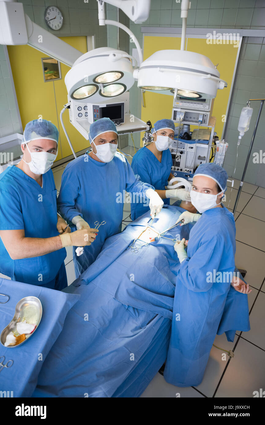 Surgery team looking at camera during operation in a surgery theater ...