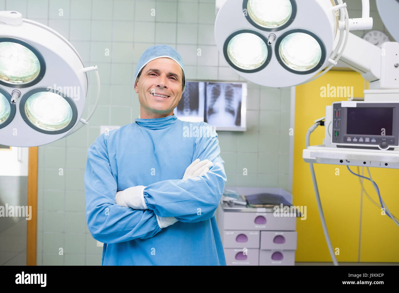 Smiling surgeon with folded arms in operating theatre Stock Photo - Alamy