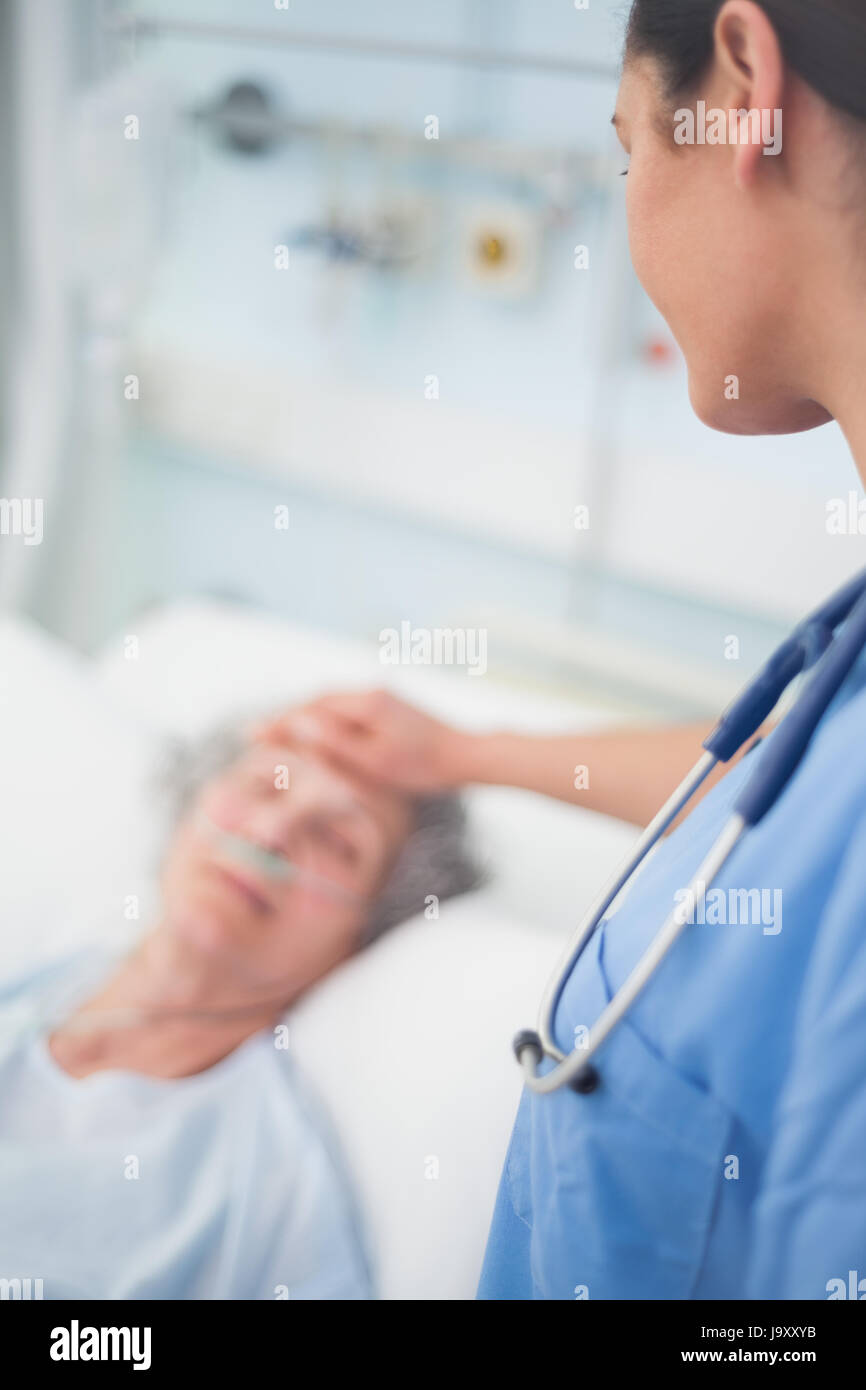 Nurse touching forehead patient hi-res stock photography and images - Alamy