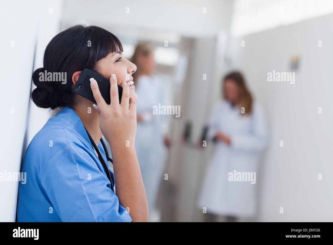 Smiling nurse holding a mobile phone in hospital ward Stock Photo - Alamy