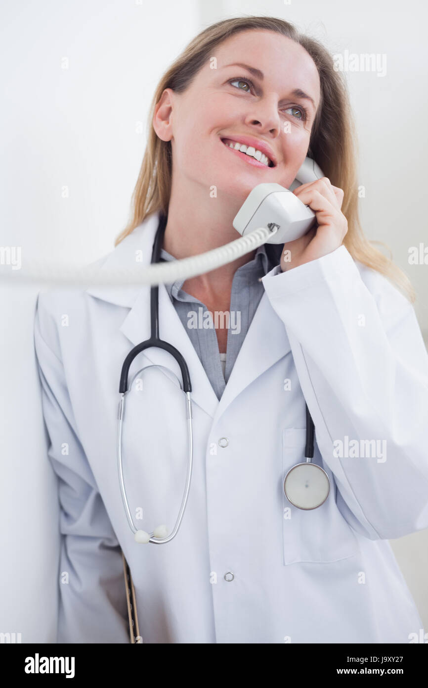 Smiling doctor holding a phone in hospital Stock Photo - Alamy