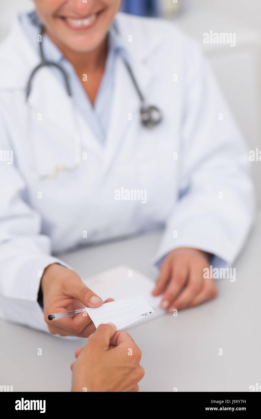 Doctor giving a paper in a medical office Stock Photo - Alamy