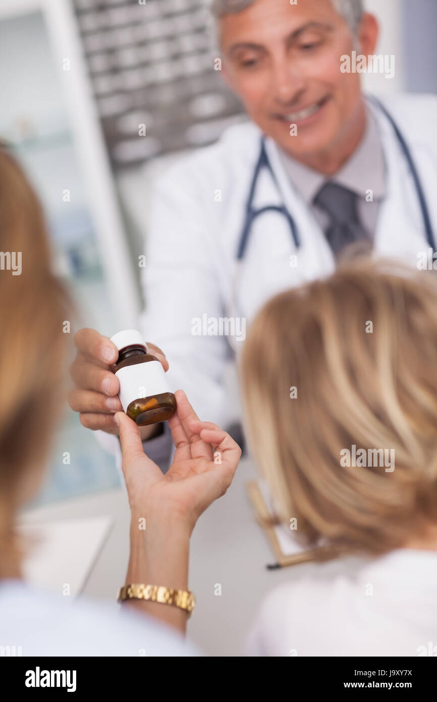 Doctor giving a bottle of drugs in a medical office Stock Photo - Alamy