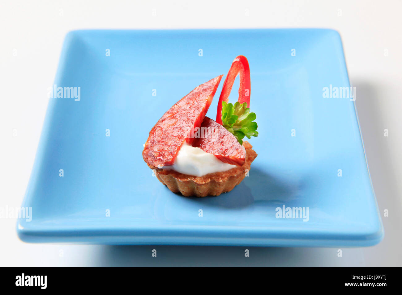 Cheese and salami snack on a blue plate Stock Photo - Alamy