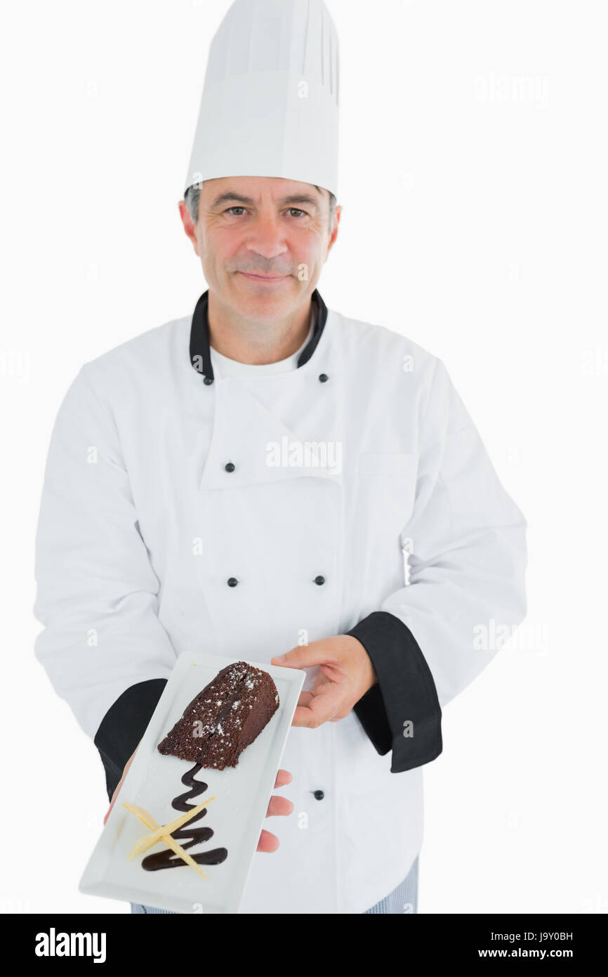 Portrait of male chef offering chocolate pastry over white background ...