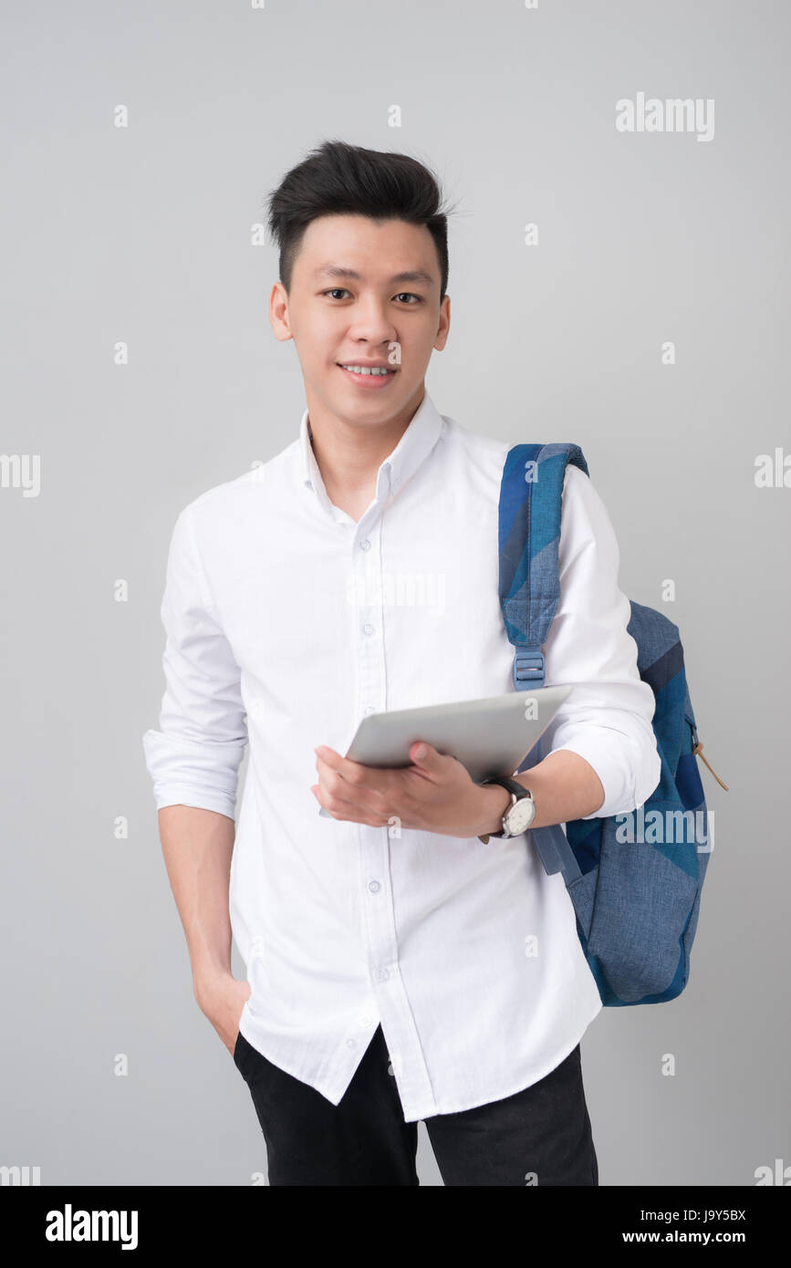 Happy casual asian male student using tablet computer isolated on a ...