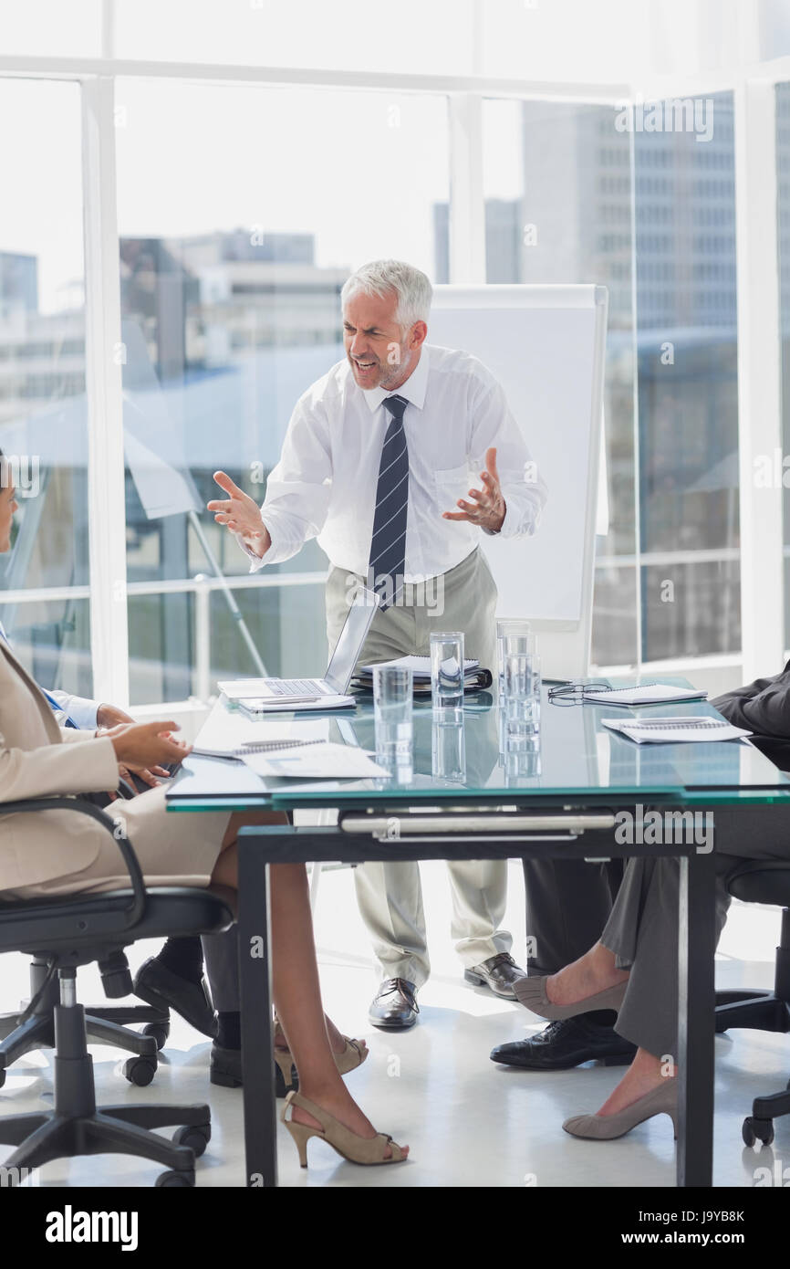Furious boss gesturing in front of employees during a meeting Stock ...