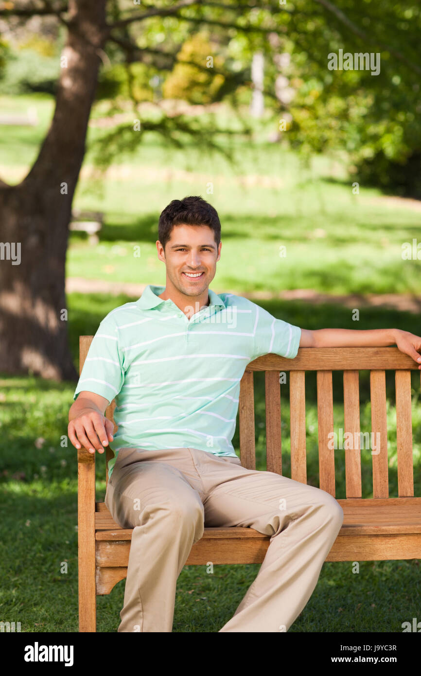 Handsome man on the bench in a park Stock Photo - Alamy