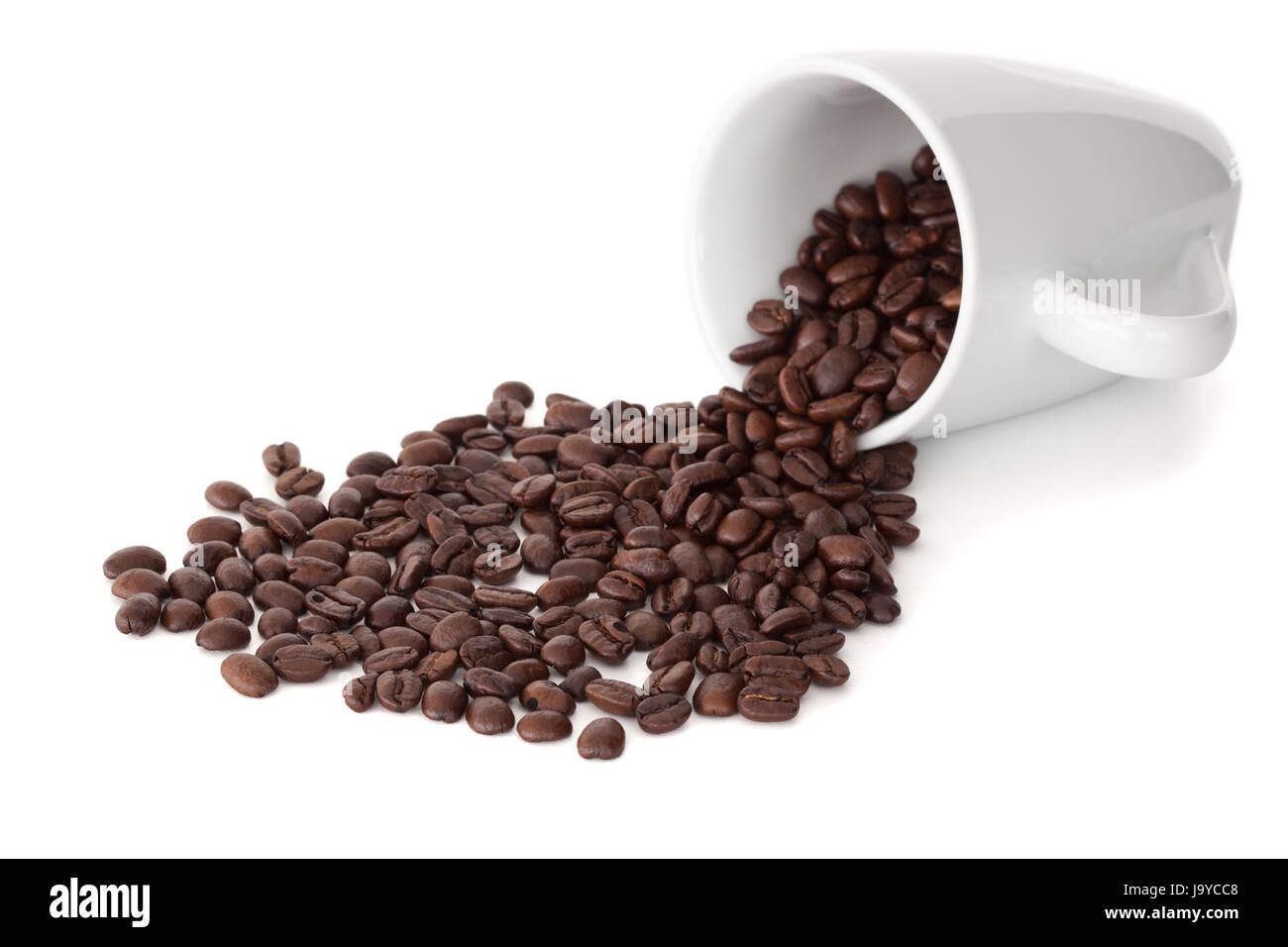 Spilled cup of coffee beans against a white background Stock Photo - Alamy