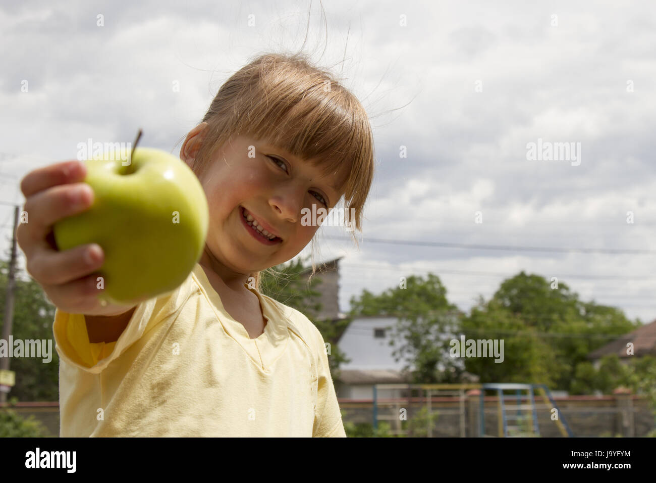 Little girl with apple outdoor Stock Photo - Alamy
