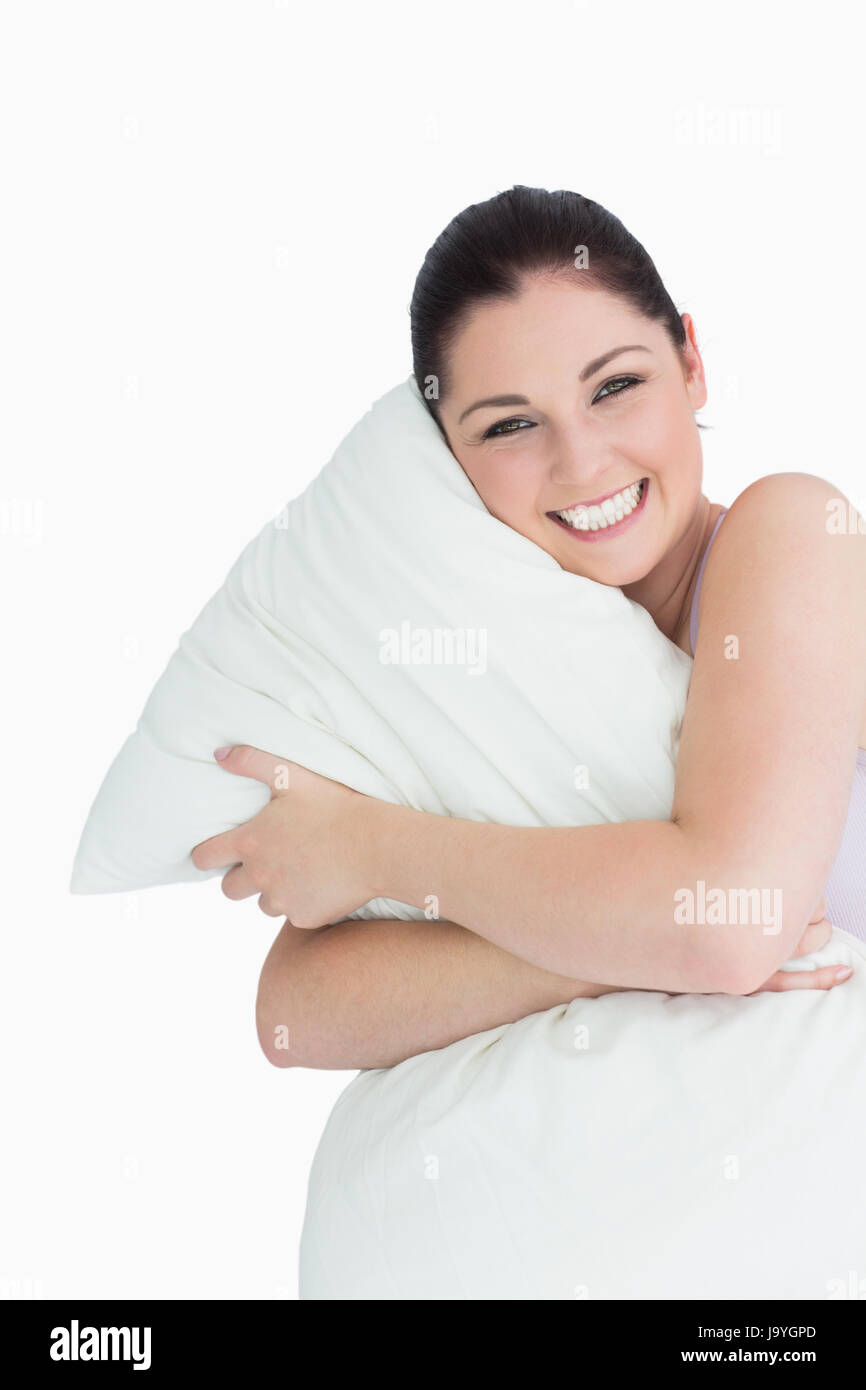 Happy woman hugging a pillow on white background Stock Photo - Alamy