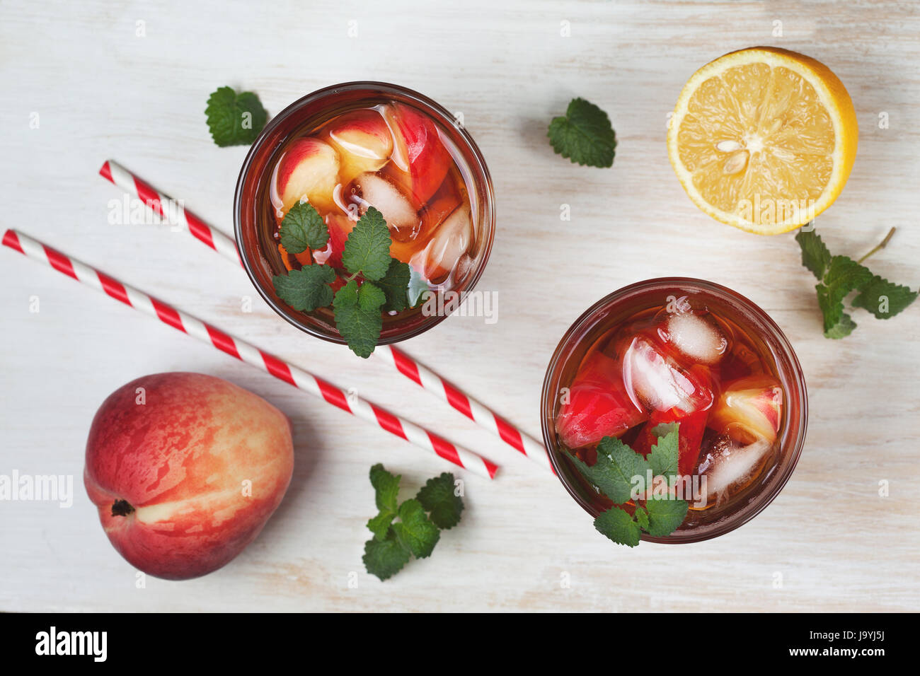 Peach ice tea in glass on white wooden background. view from above ...