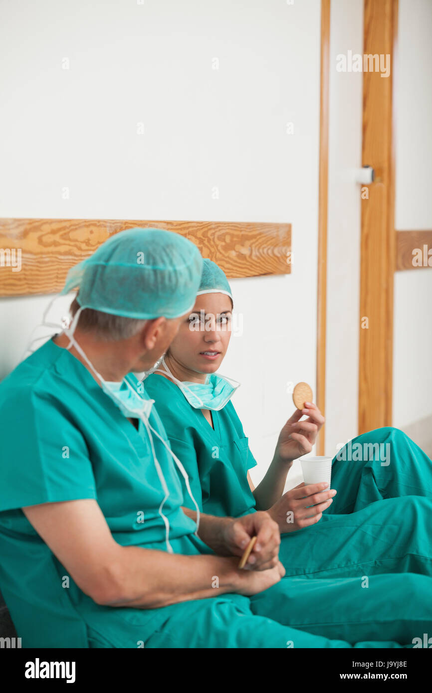 Surgeons eating biscuits in hospital hallway Stock Photo - Alamy
