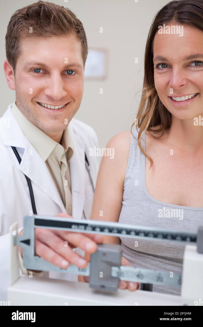 Doctor and patient setting up medical scale Stock Photo - Alamy