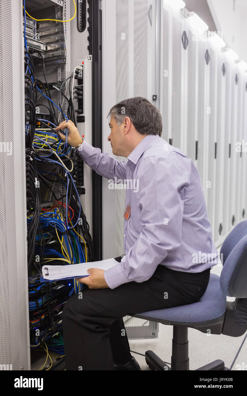 Technician with a clipboard checking servers in data center Stock Photo - Alamy