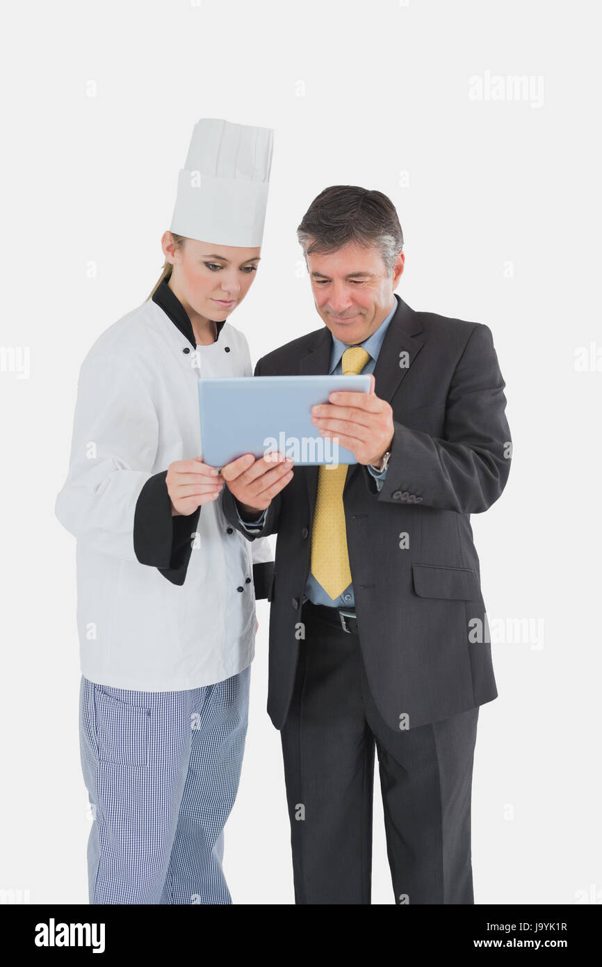 Female chef and businessman using digital tablet over white background ...