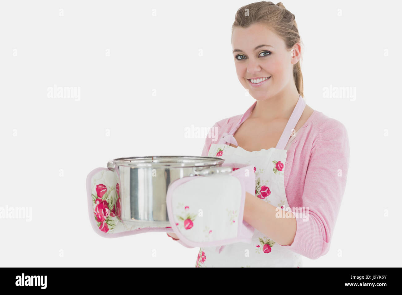 Portrait of happy young maid holding cooking utensil over white ...