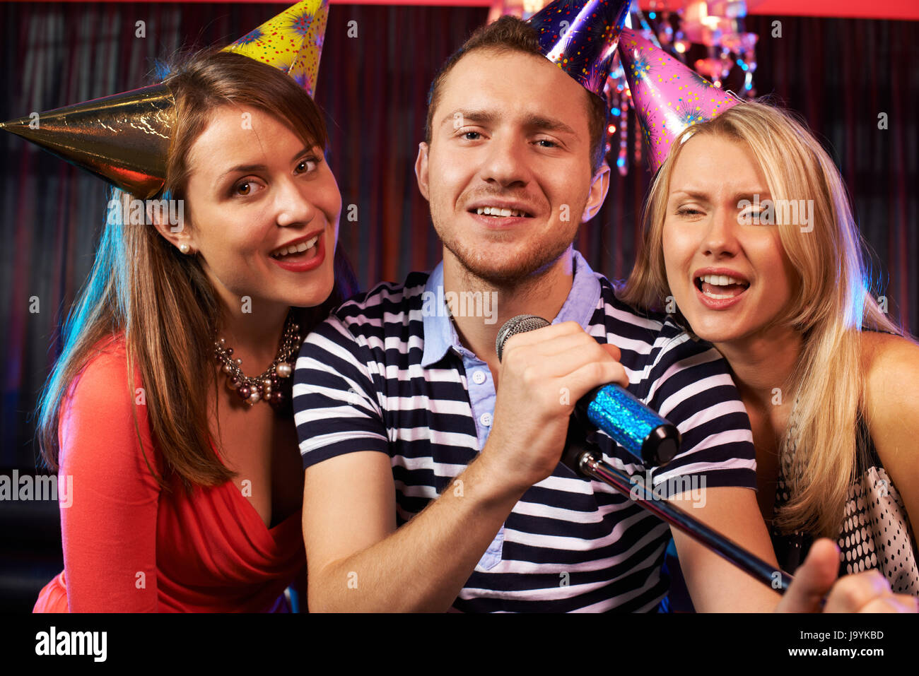 Portrait of happy people singing in microphone in the karaoke bar Stock ...