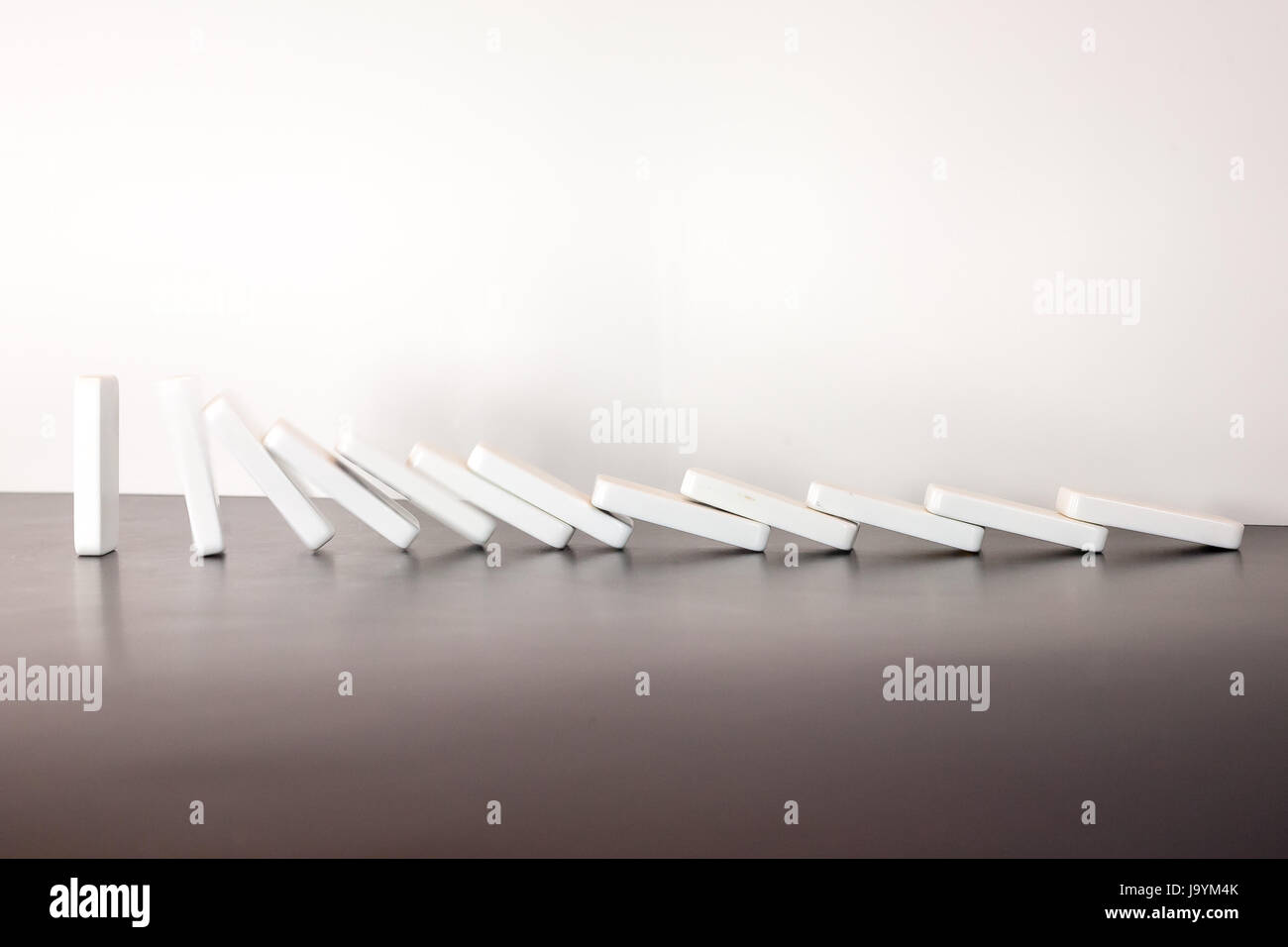 A row of falling dominos in motion Stock Photo - Alamy