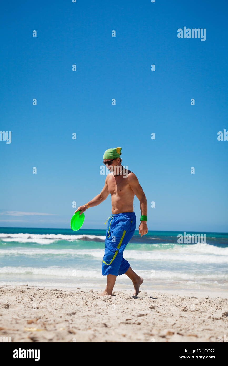 sporty man playing frisbee on the beach in summer frisby Stock Photo ...
