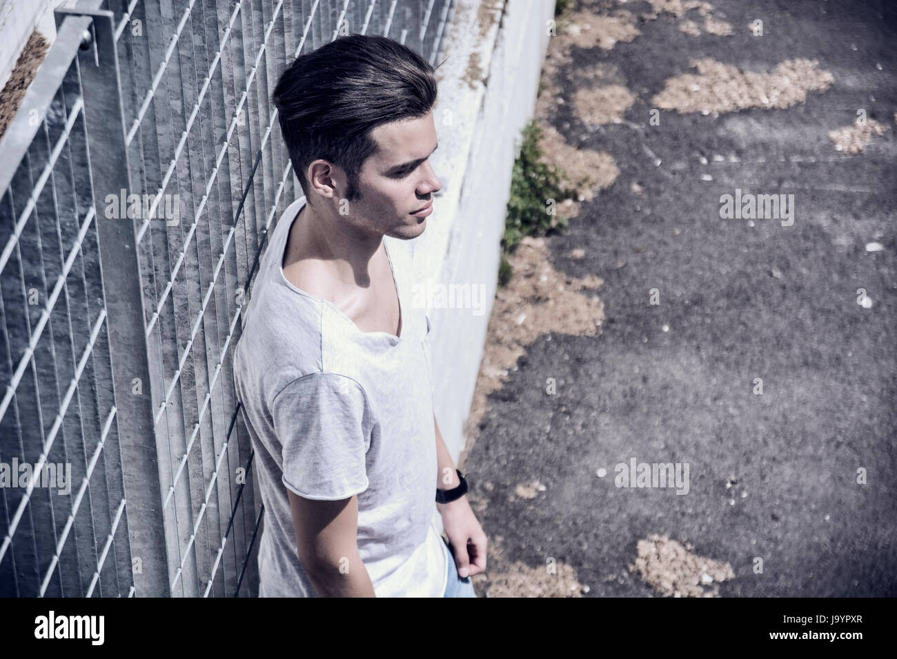 Profile shot of attractive young man in city by a street, looking away ...