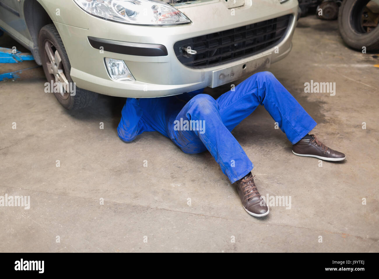 Male mechanic under car Stock Photo - Alamy
