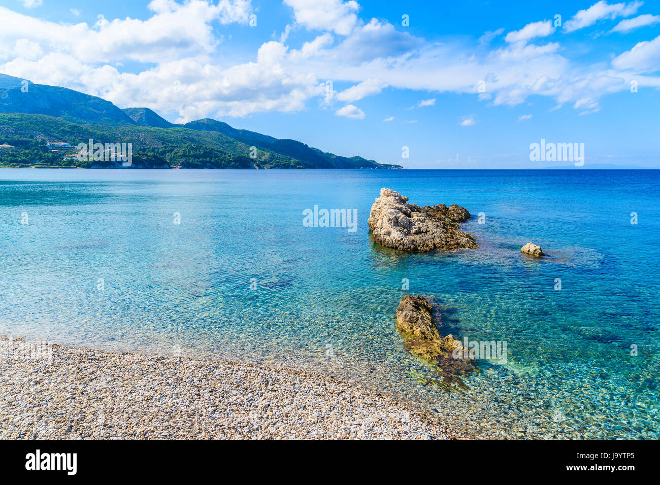 Beautiful pebble stone beach with rocks in Kokkari village on sunny ...