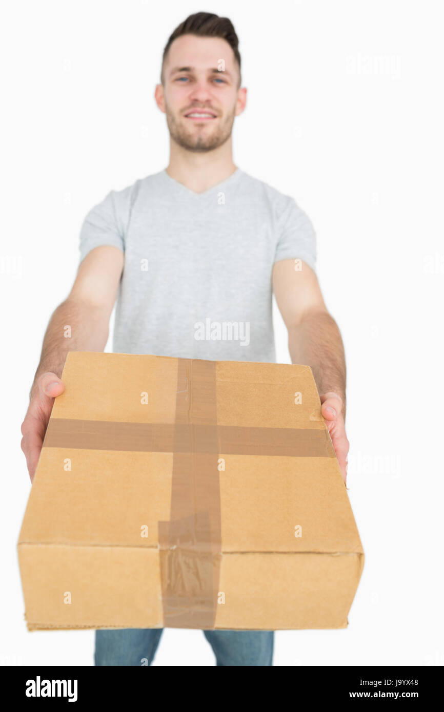 Portrait of young man giving you a package box over white background ...