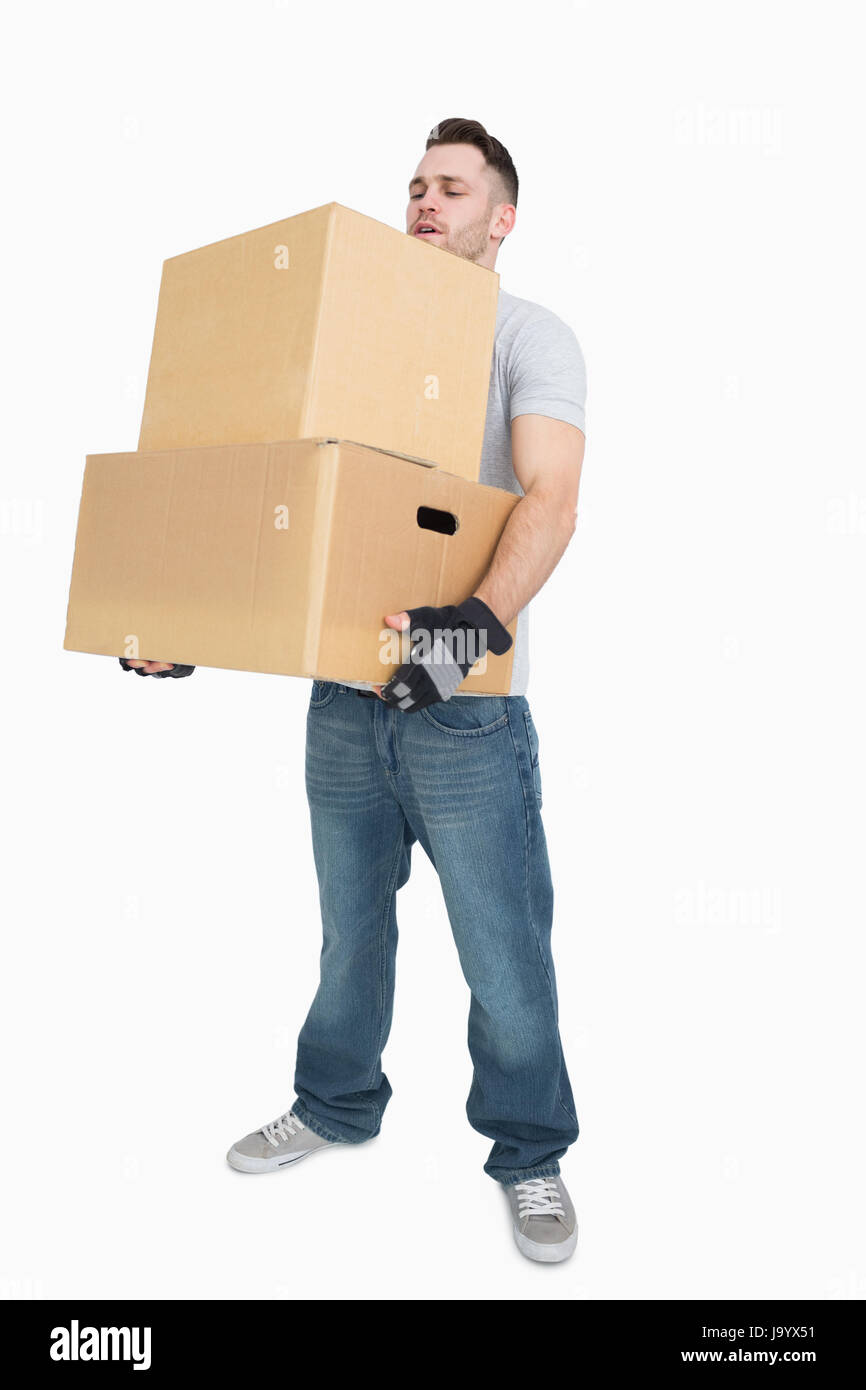 Young man carrying package boxes over white background Stock Photo - Alamy