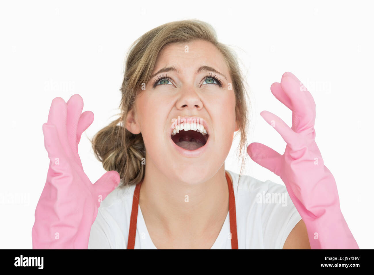 Closeup of young maid in pink gloves screaming over white background ...