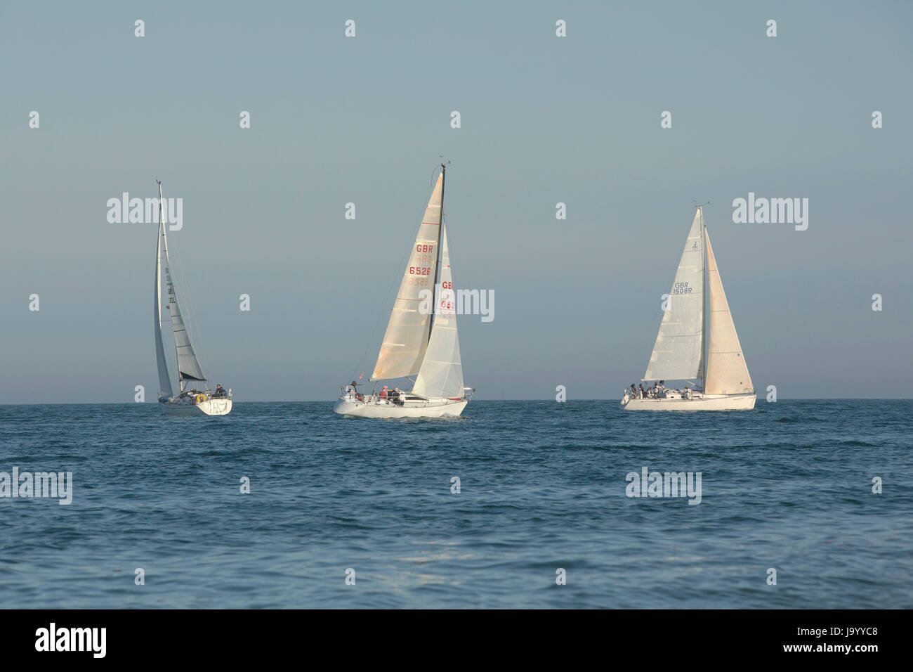 Group of three sailing boats on a sunny spring evening at the entrance ...