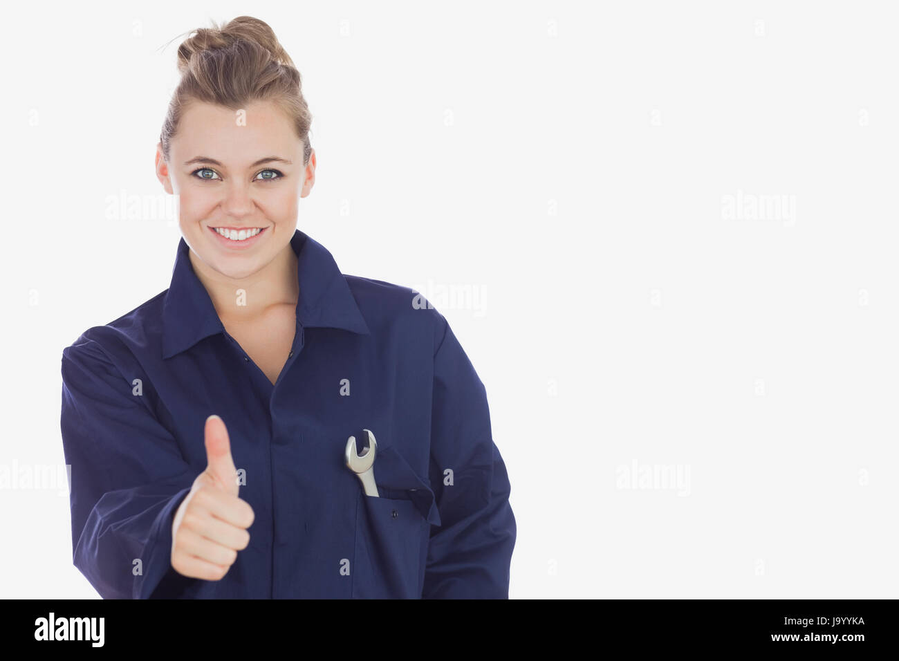 Portrait of female technician showing thumbs up sign over white ...