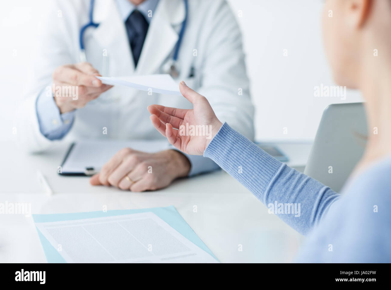 Doctor in his office giving a medical prescription to the patient ...