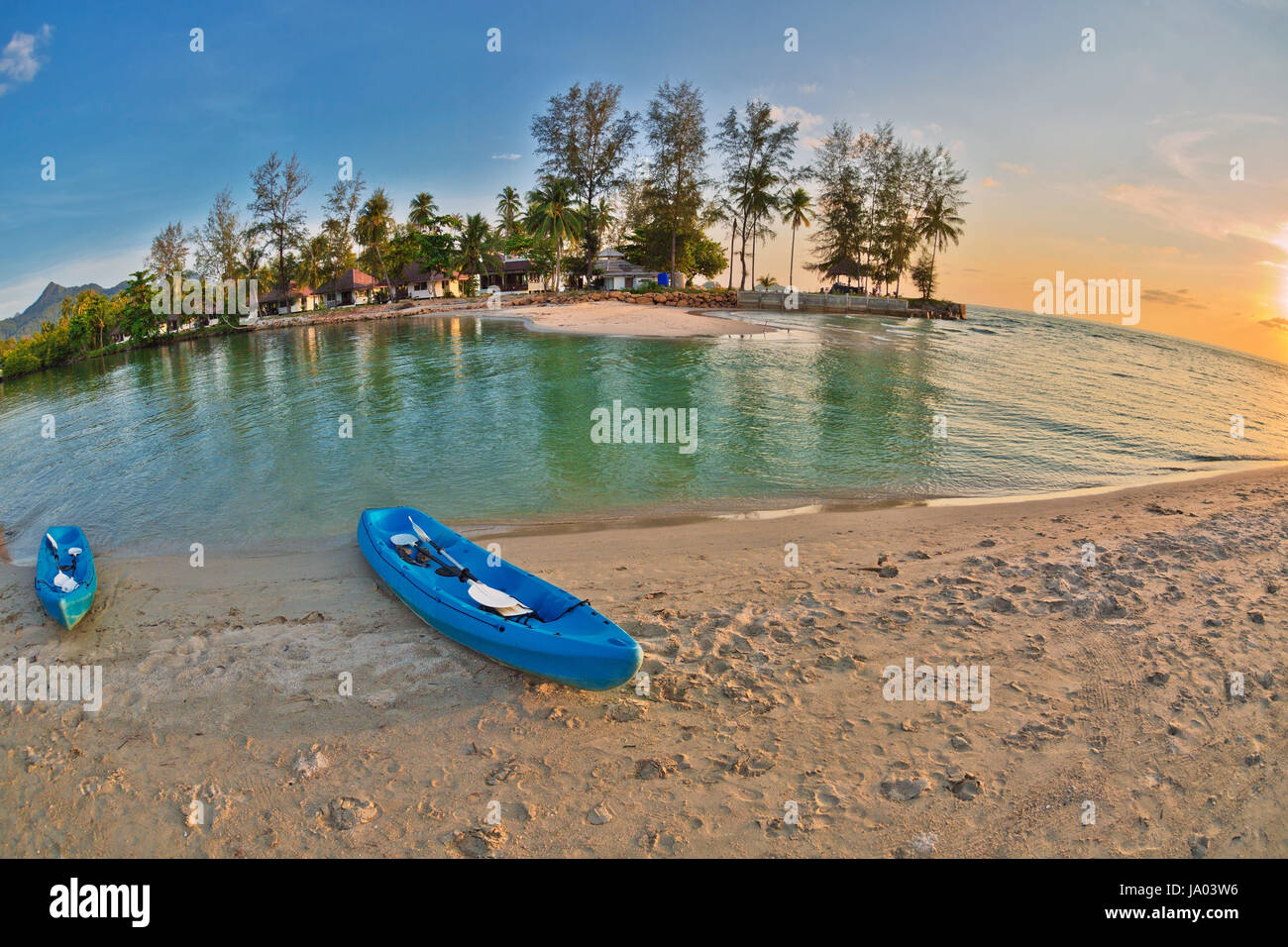 Kayaks on the beach during sunset Stock Photo - Alamy